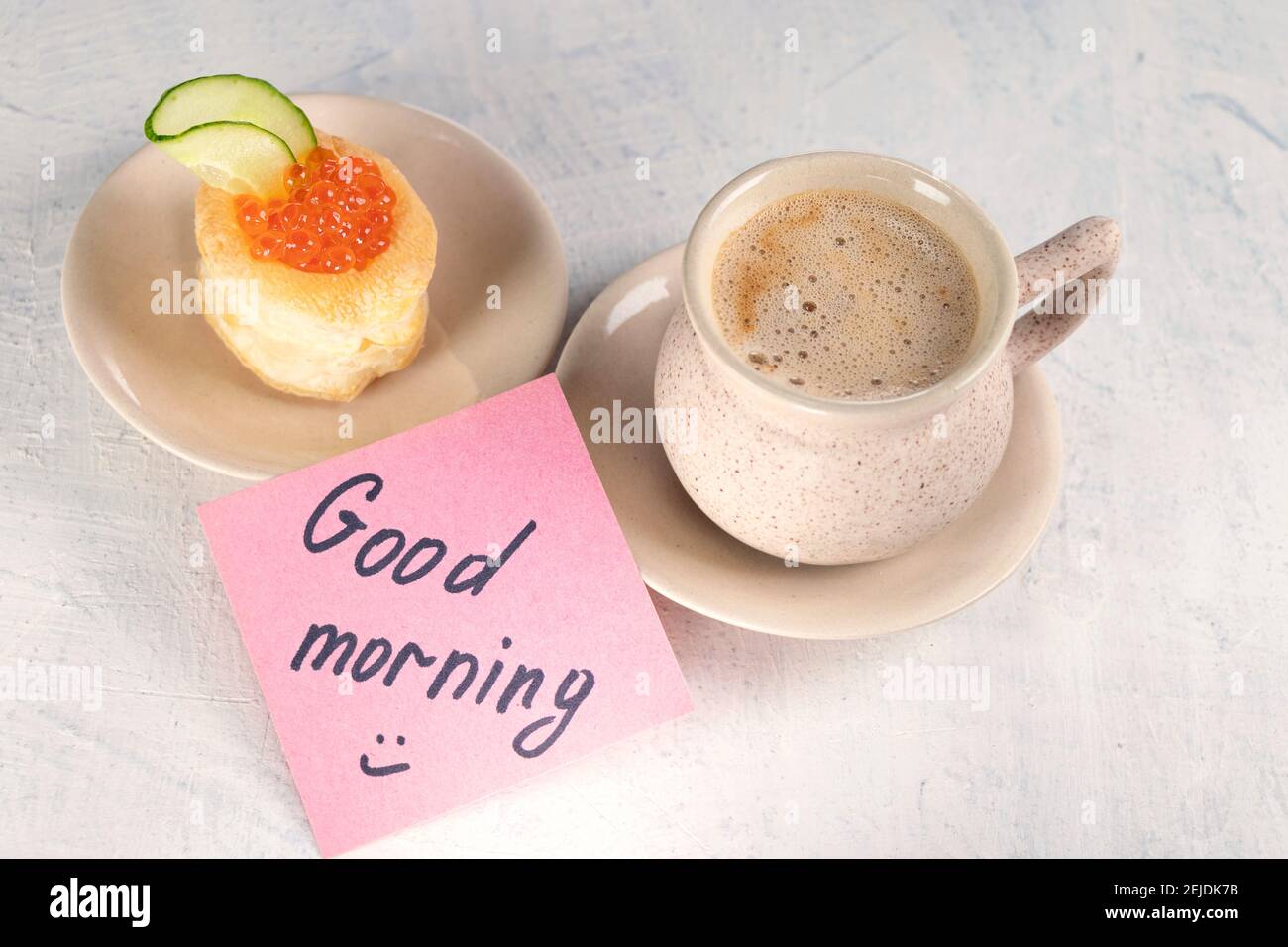 Cup of coffee, appetizer with red caviar and a note with the words GOOD ...
