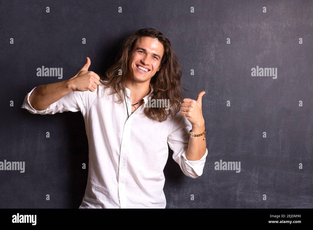 Happy handsome man with long hair with expression shows thumbs up. Good ...