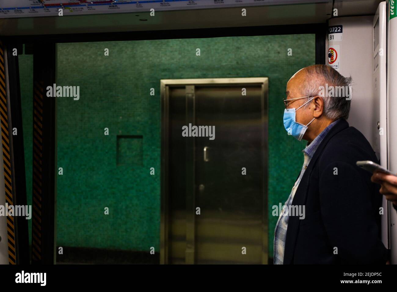 A man wears a face mask on the MTR subway in Hong Kong following ...