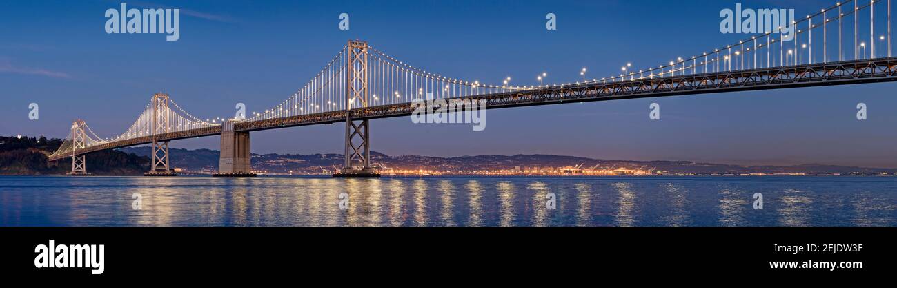 Suspension bridge over Pacific ocean lit up at dusk, Bay Bridge, San ...