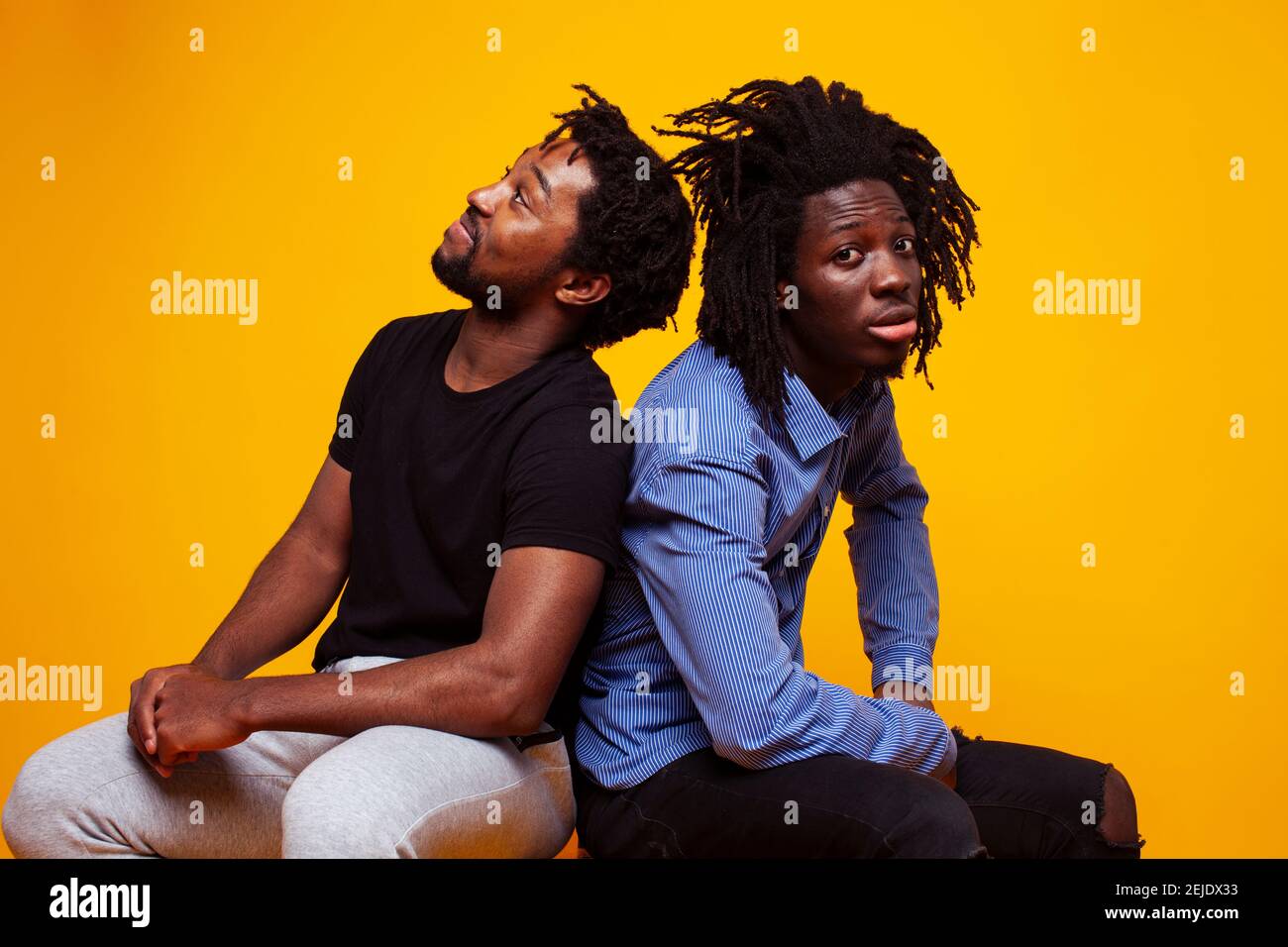 two african american guys posing cheerful together on yellow background ...
