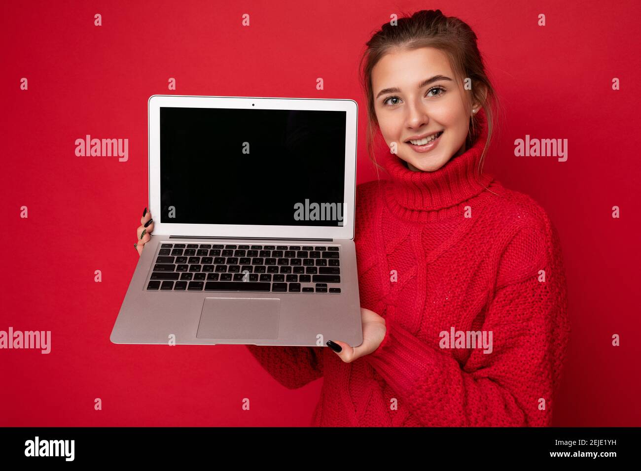 Photo of beautiful young woman holding computer laptop looking at ...