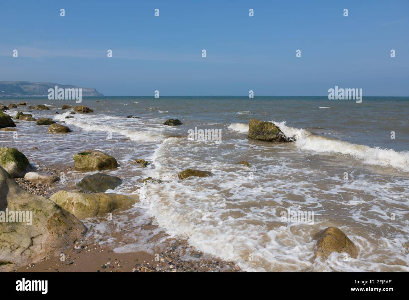 Wave splashing on the rocks at the base of the little Orme, Llandudno ...