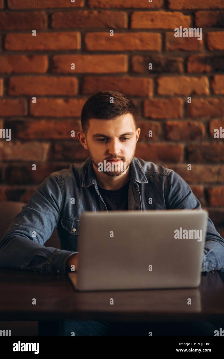 Bearded programmer working on a laptop in a cafe Stock Photo - Alamy