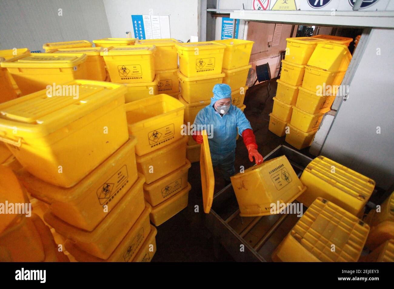 A Chinese worker lines up empty plastic medical waste boxes for ...