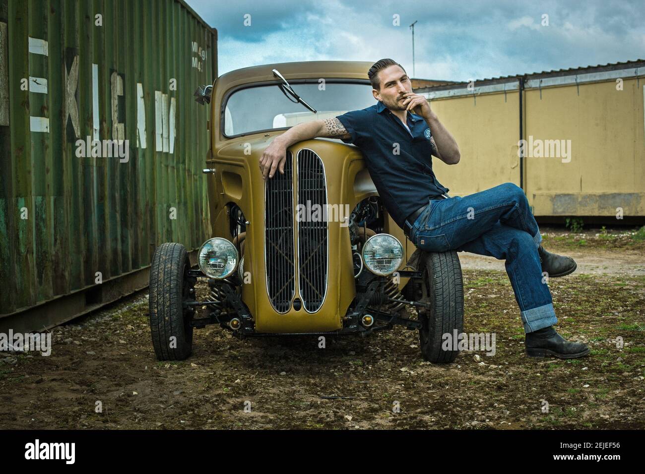 Ford Popular 1958 Hot Rod . young man in jeans sitting on his car and ...