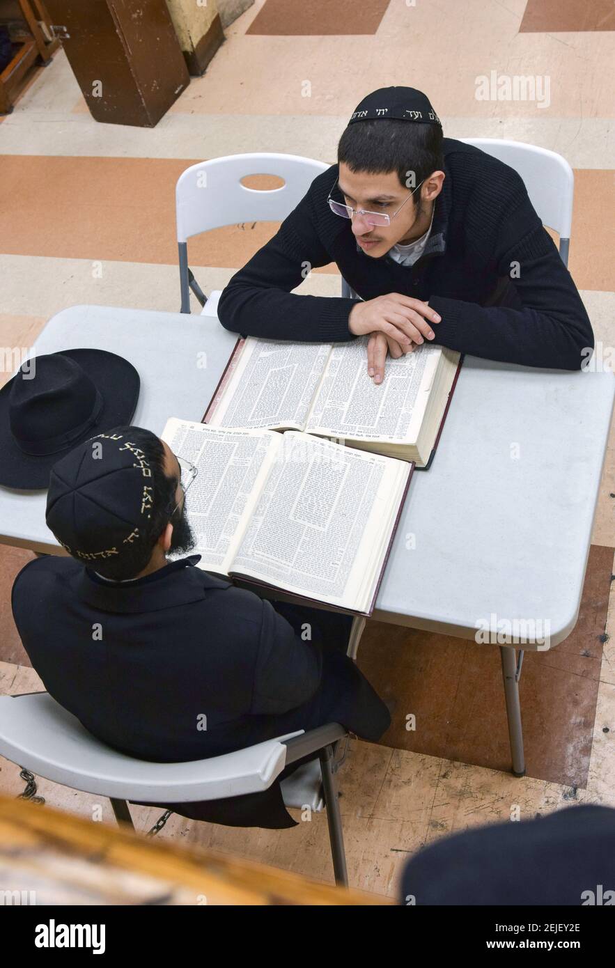 2 orthodox Jewish young man study Talmud together is system of learning ...