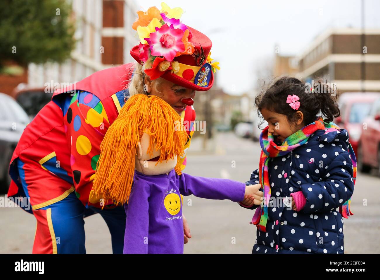 A clown dressed in full costume with a child before the annual Grimaldi ...