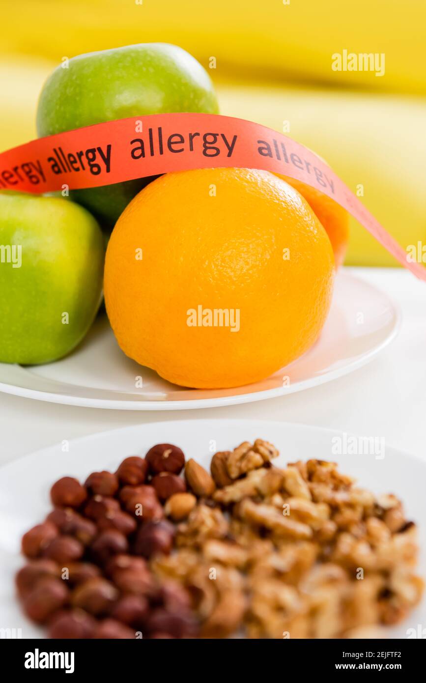 Ribbon with allergy lettering near fresh fruits and nuts on blurred ...