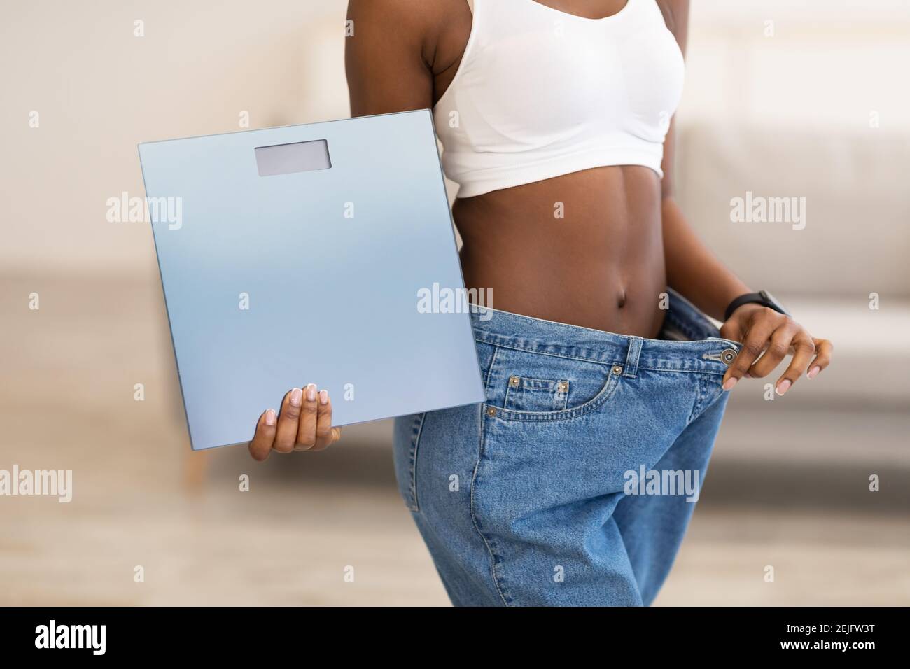 Slim Woman Holding Scales Wearing Large Jeans After Slimming Indoors ...