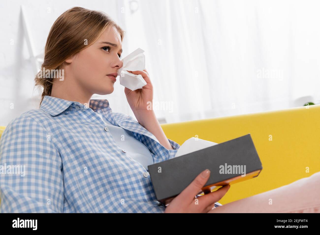 Young woman holding box and napkins during allergy Stock Photo - Alamy