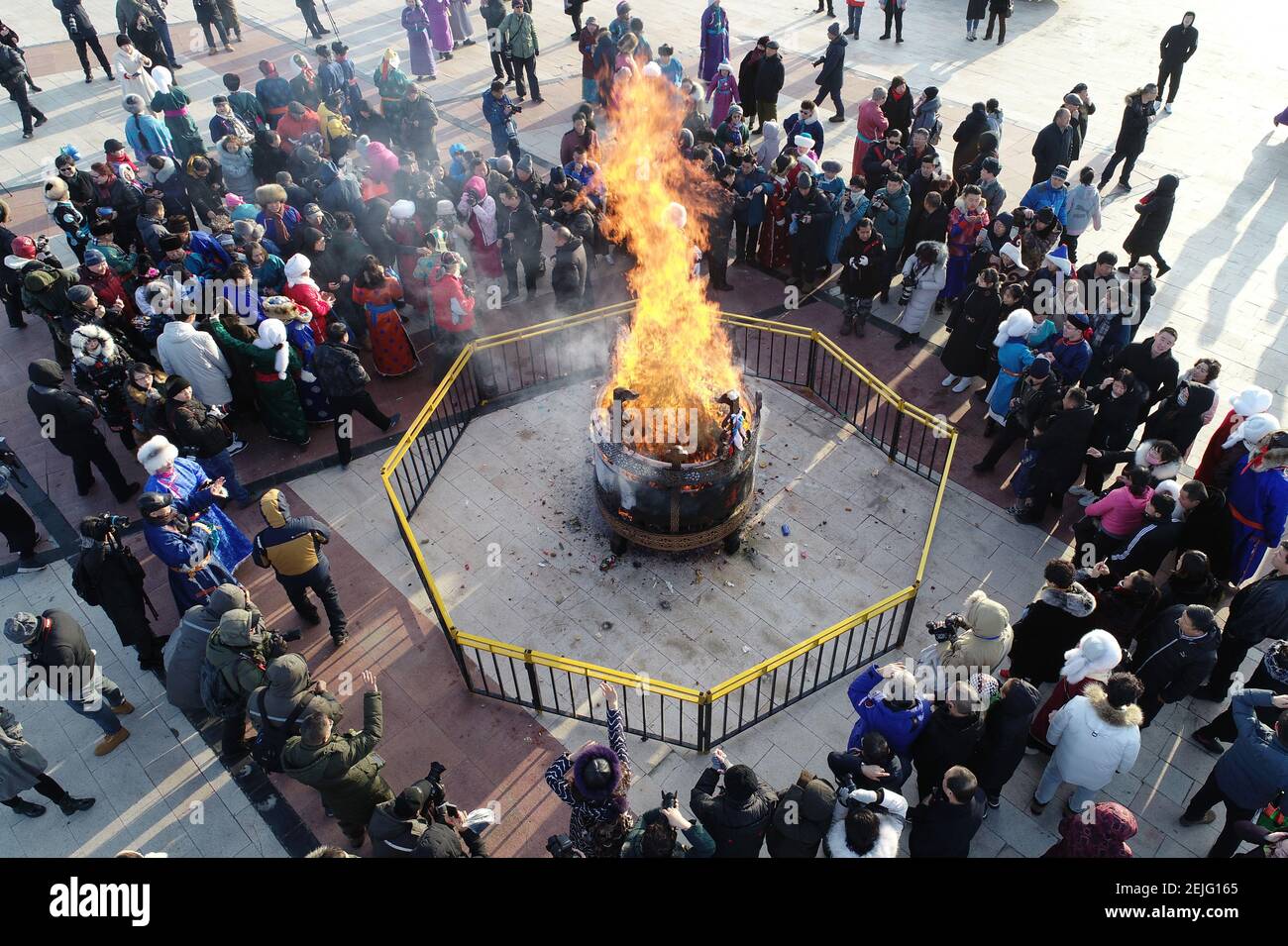 An aerial view of crowd surrounding a bonfire at a ceremony to ...