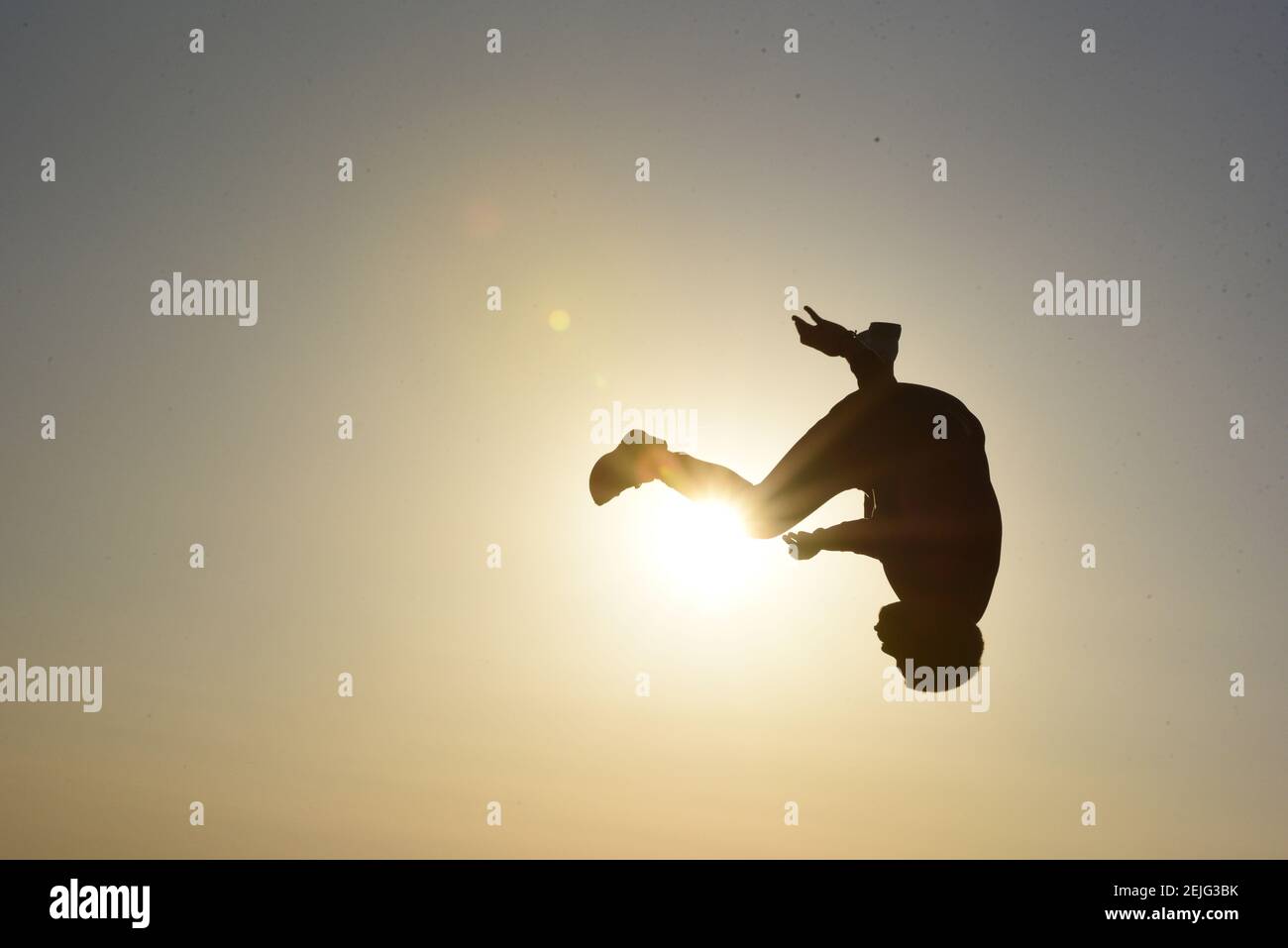 A man somersaults at sunset amidst smog. Air pollution in Madrid is ...