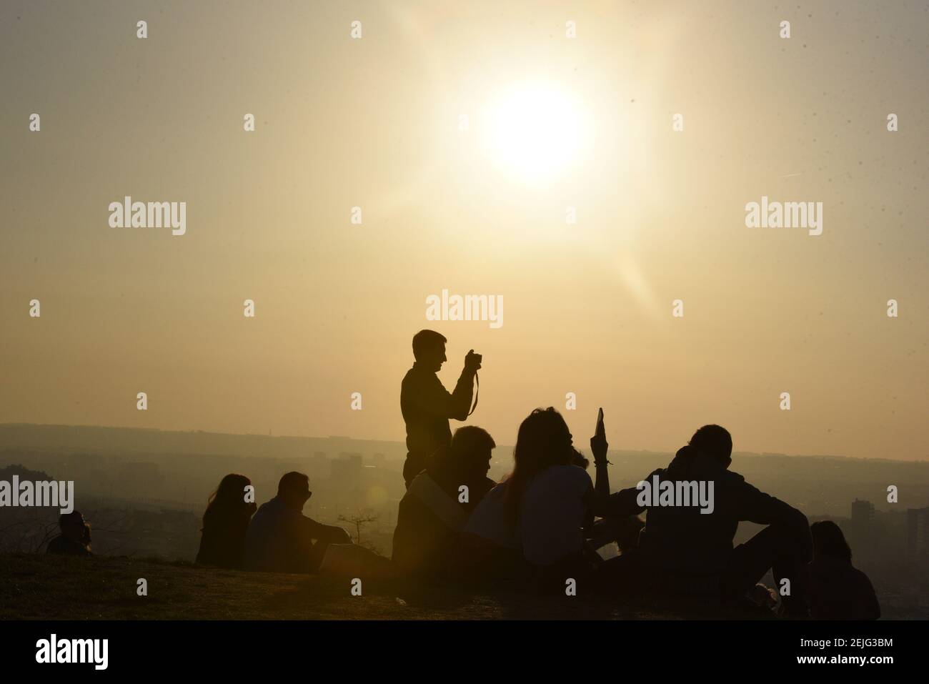 A man taking pictures at sunset amidst smog. Air pollution in Madrid is ...