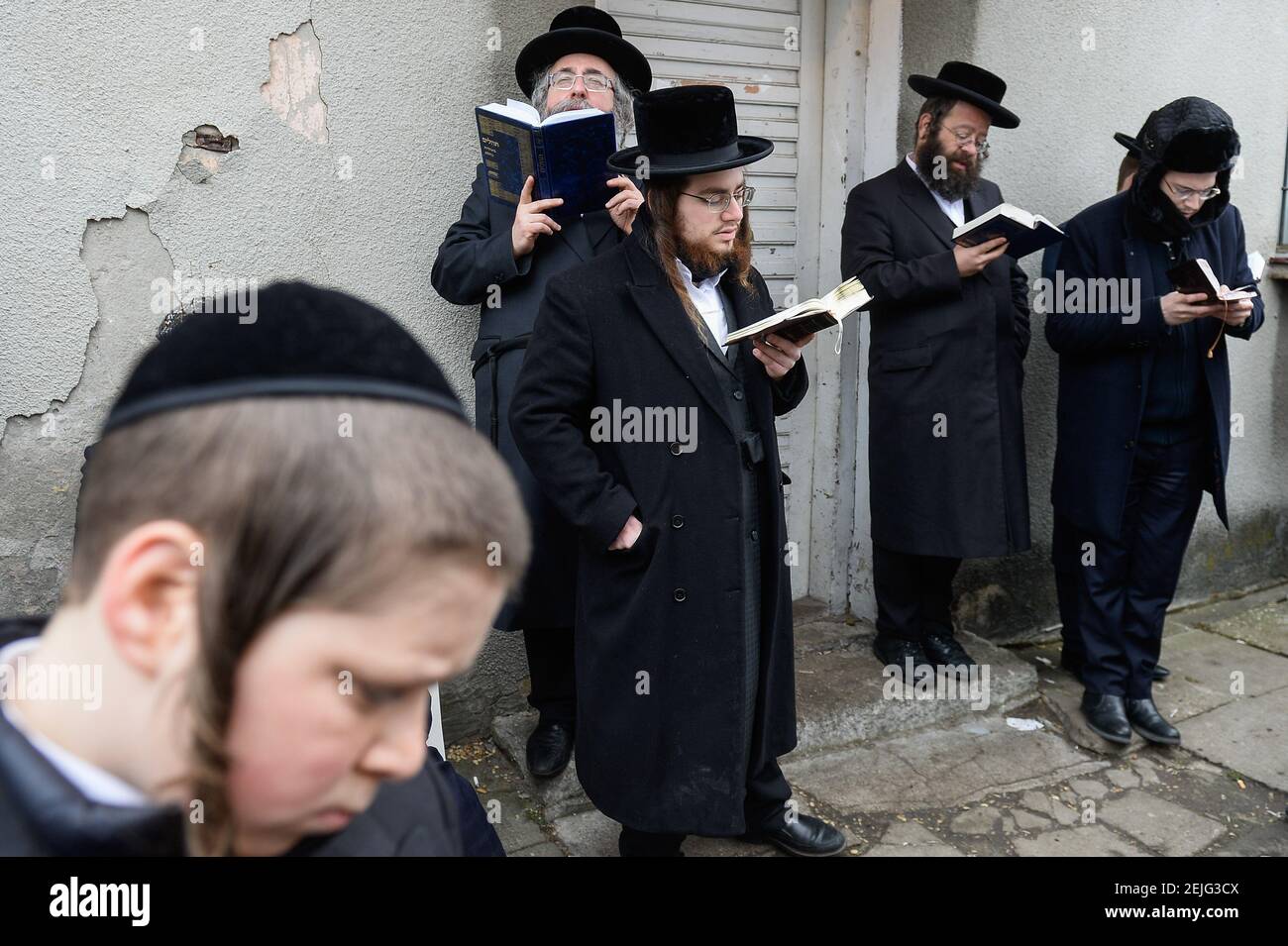 Hasidic Jews pray together outisde the building where Dawid Biderman ...