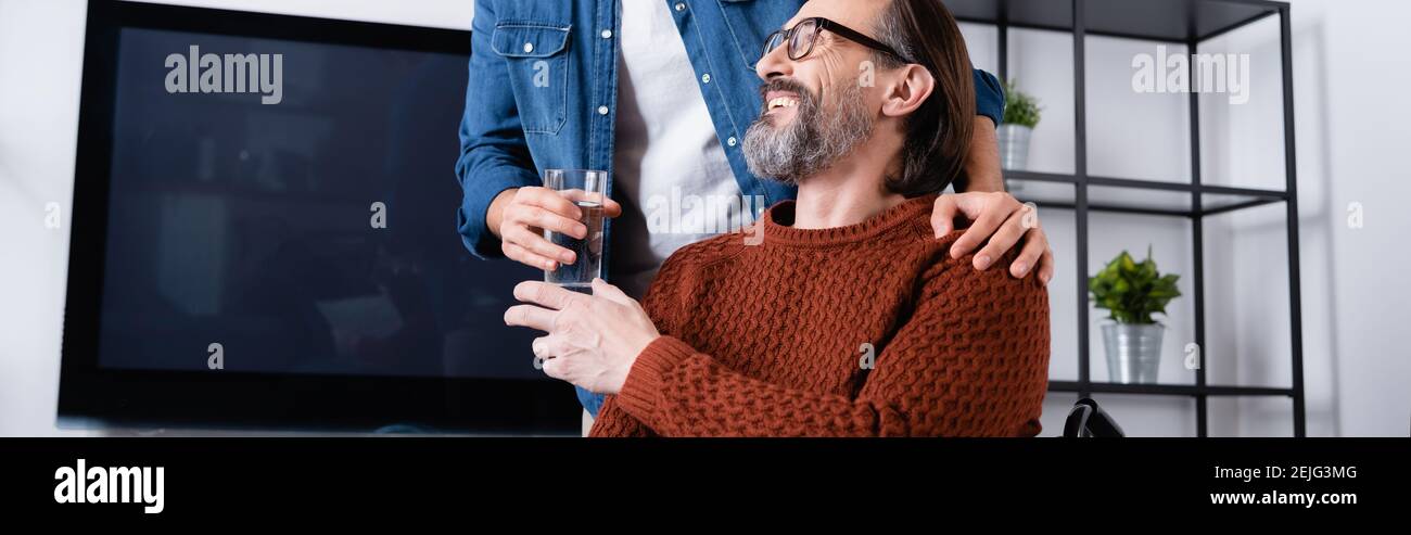 man giving glass of water to happy father, banner Stock Photo - Alamy