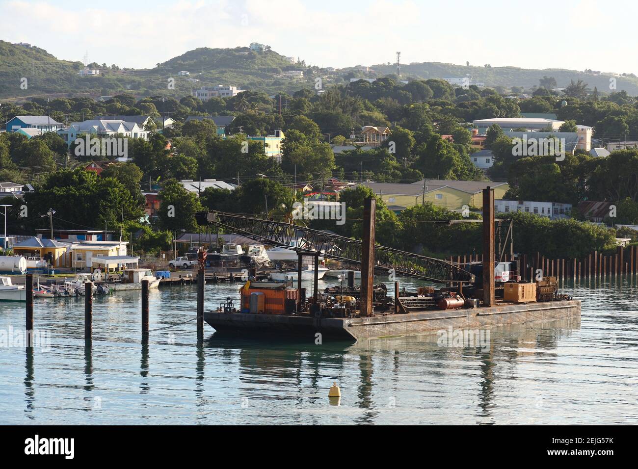 Side view of Crane Barge lifting and securing piles into waters edge at ...
