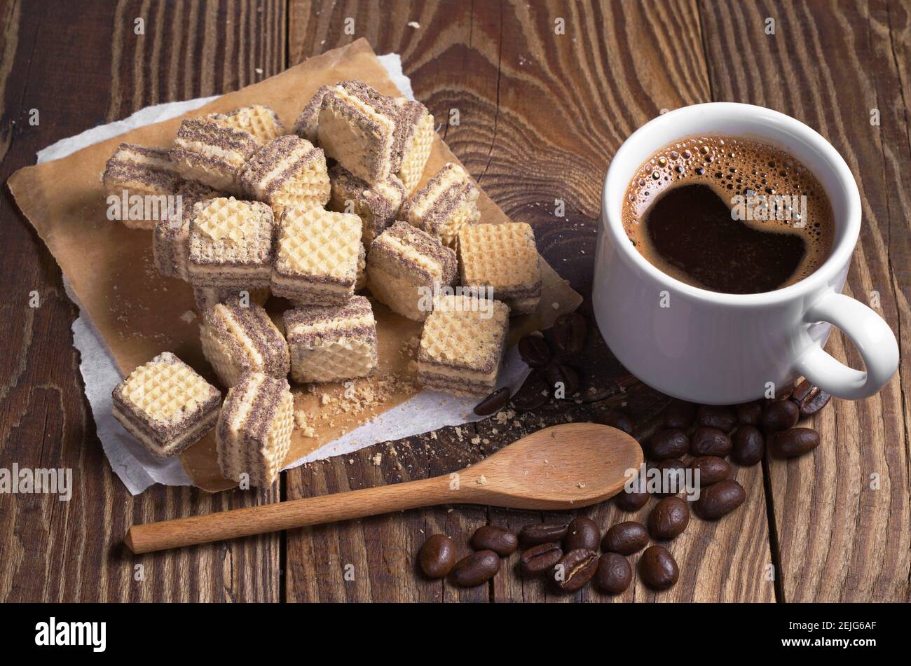 Cup of hot coffee and small chocolate wafers on old wooden table Stock ...