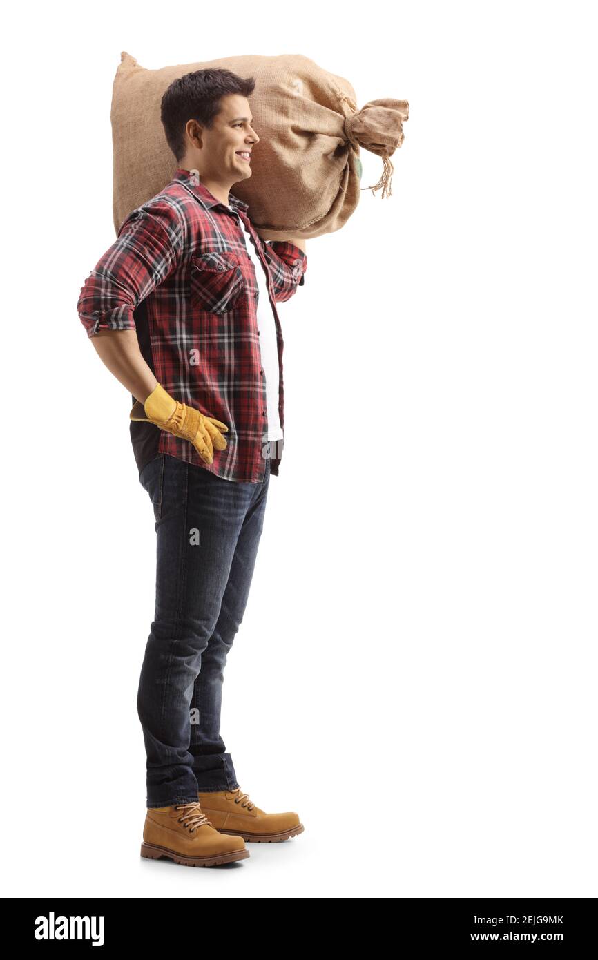 Full length profile shot of a young farmer carrying a sack on his ...