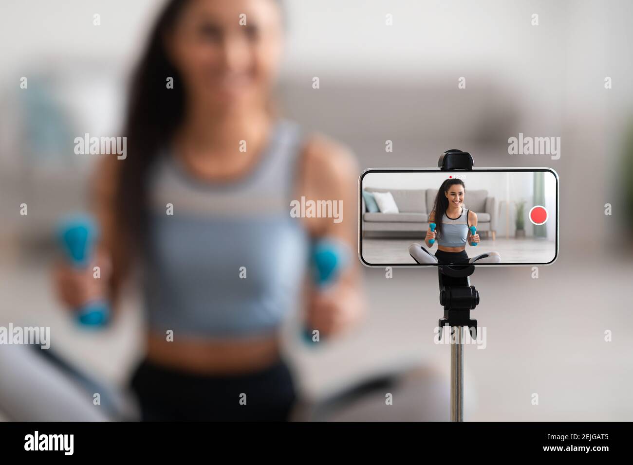 Selective focus on smartphone screen shooting woman fitness trainer ...