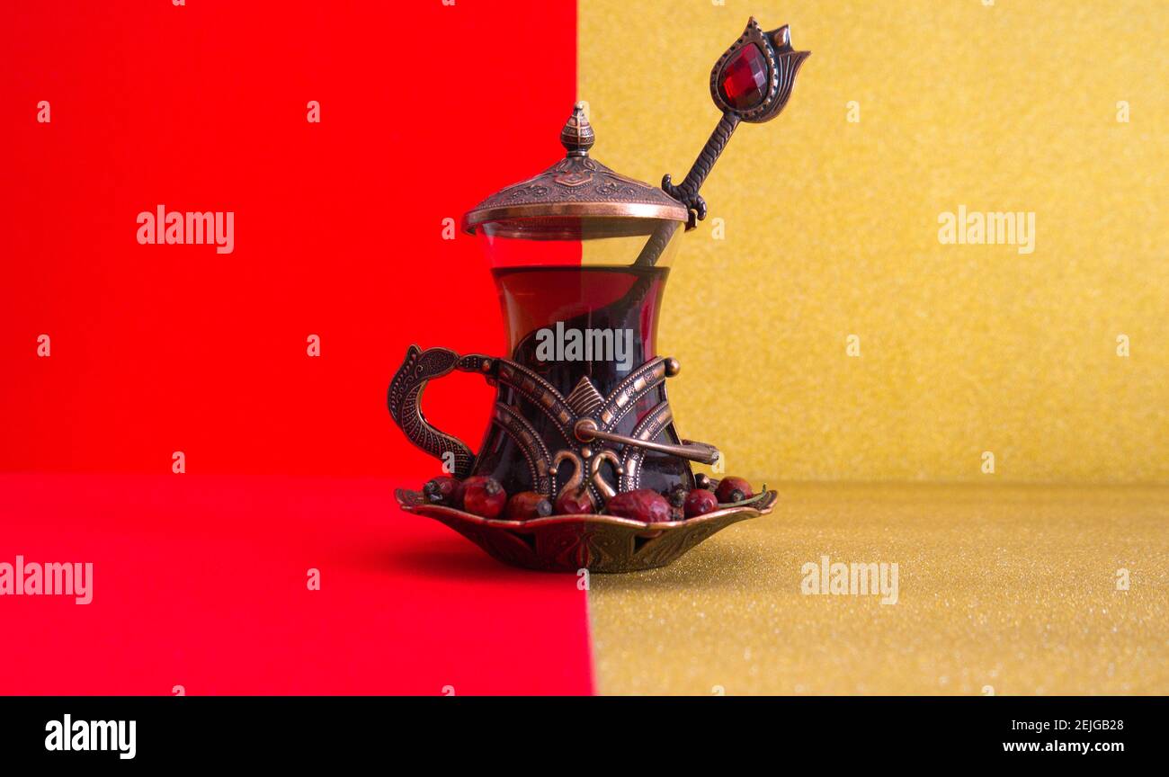 Turkish teacup with spoons on red-yellow shiny background Stock Photo ...