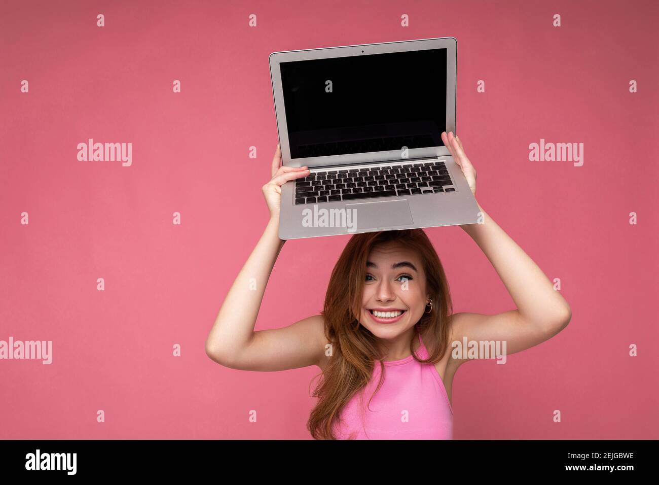 Photo of happy satisfied Beautiful young blond woman holding computer ...