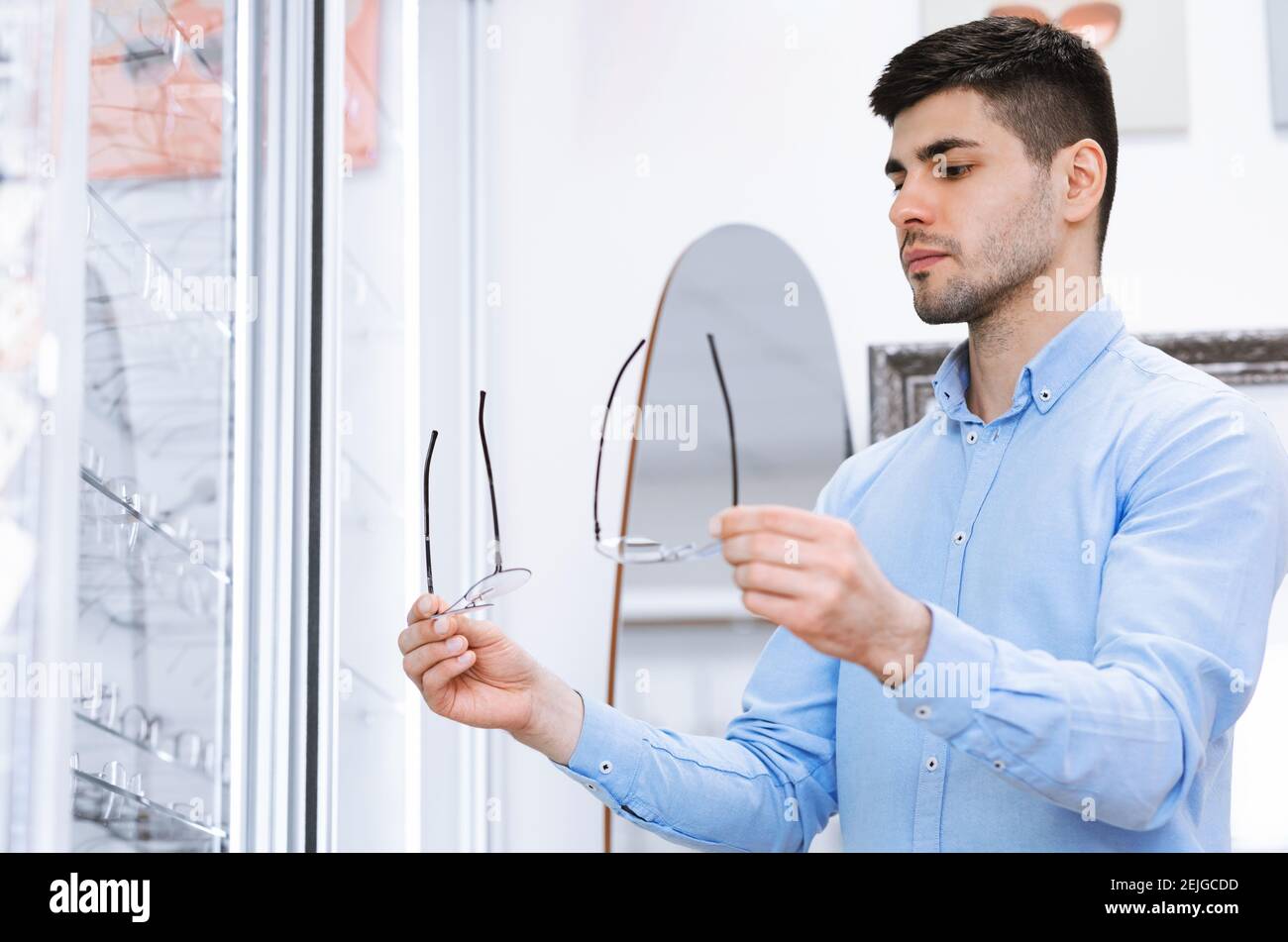 Portrait of handsome young customer choosing spectacles Stock Photo - Alamy