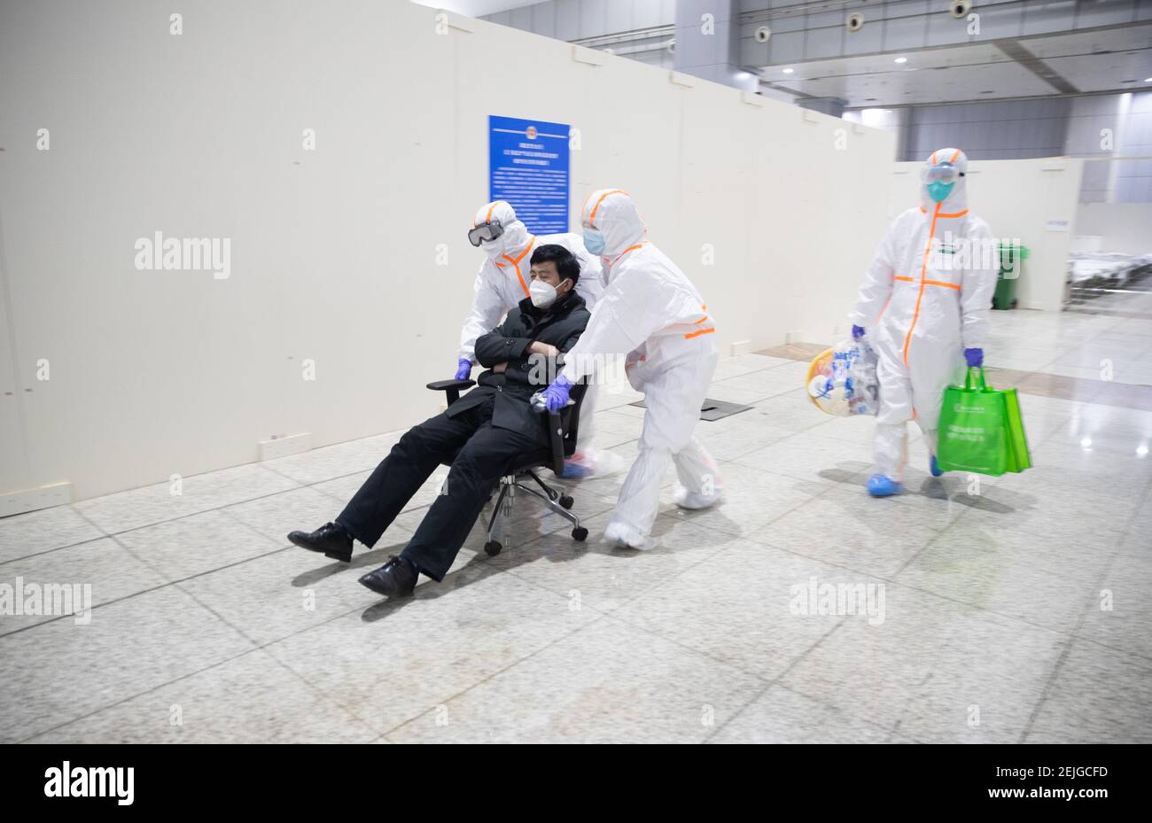 Chinese medical workers escort a patient infected with the new ...