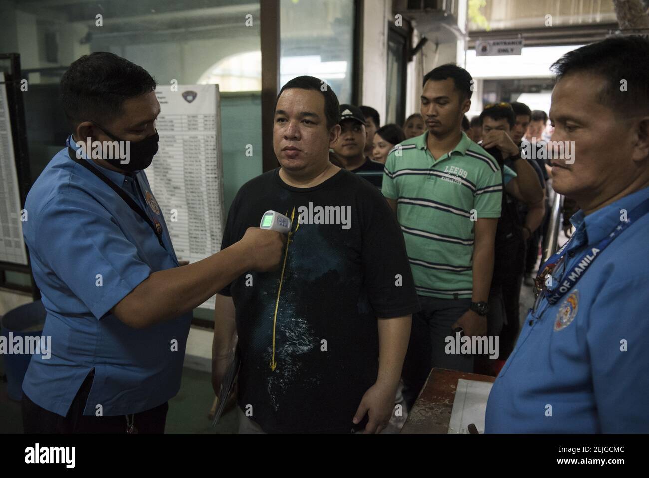 A health worker measures the body temperature of a government employee ...