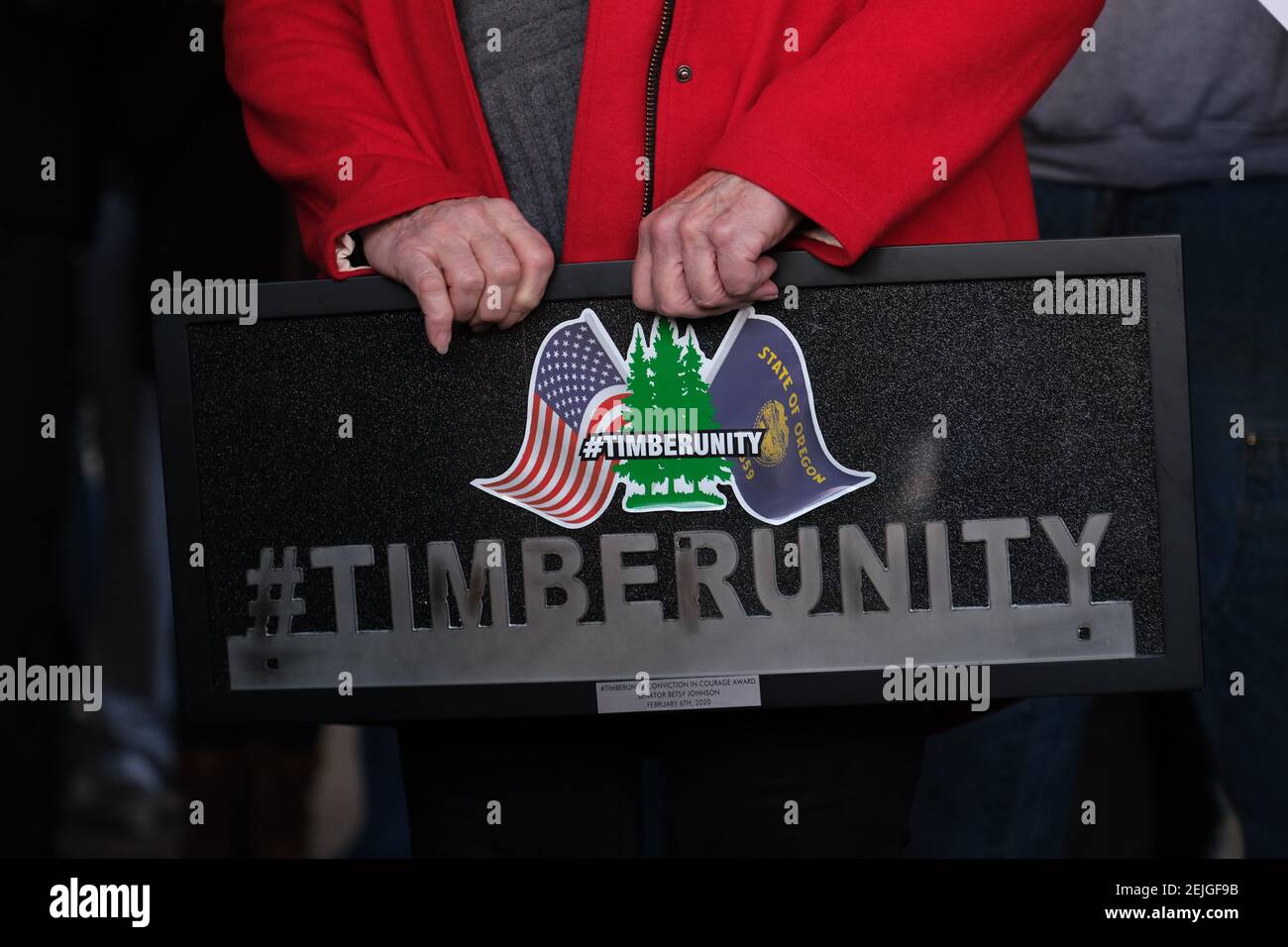 A woman holds an award given to Democratic senator Betsy Johnson as ...