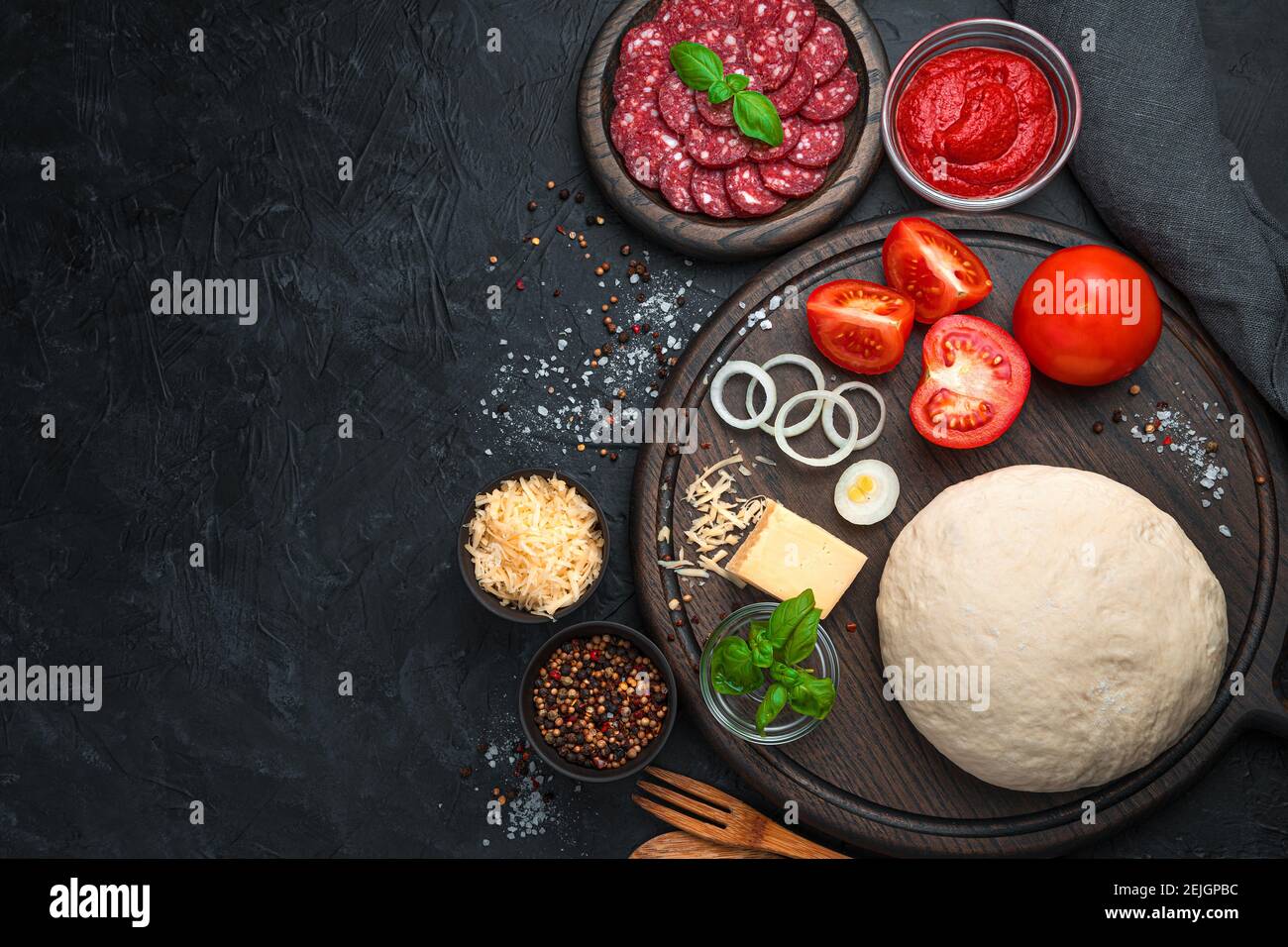 Pizza ingredients on a black background. Top view with copy space ...