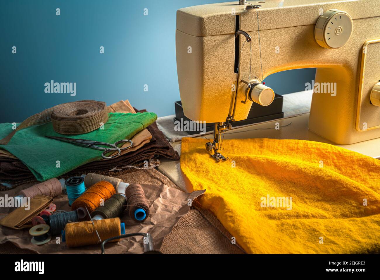 Colorful sewing background with sewing machine and accessories on blue ...