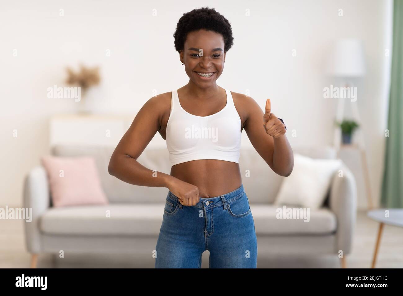 Skinny Black Lady Gesturing Thumbs-Up Wearing Small Jeans Standing ...