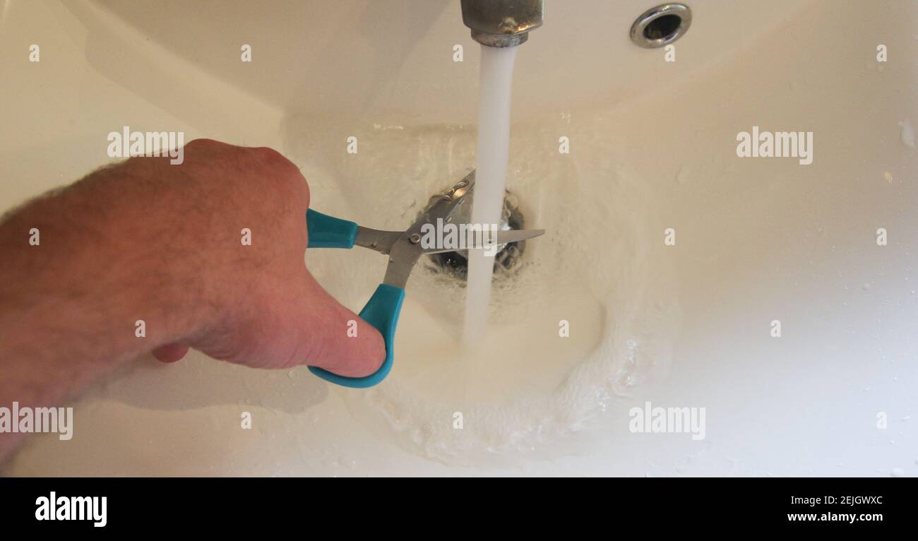 Hand holding opened scissor ready to cut Stock Photo - Alamy