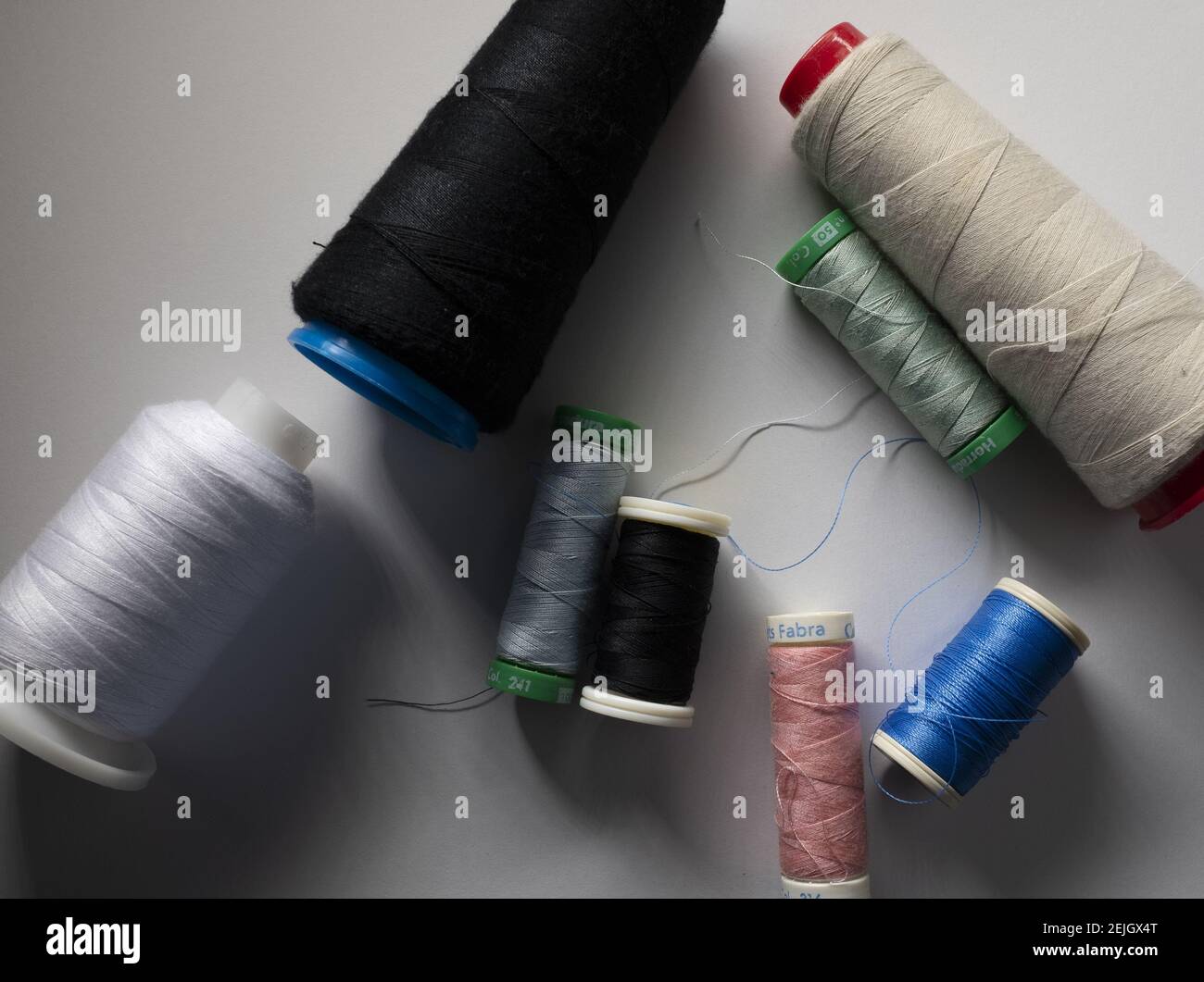 Overhead shot of rolls of thread for sewing with various colors and ...