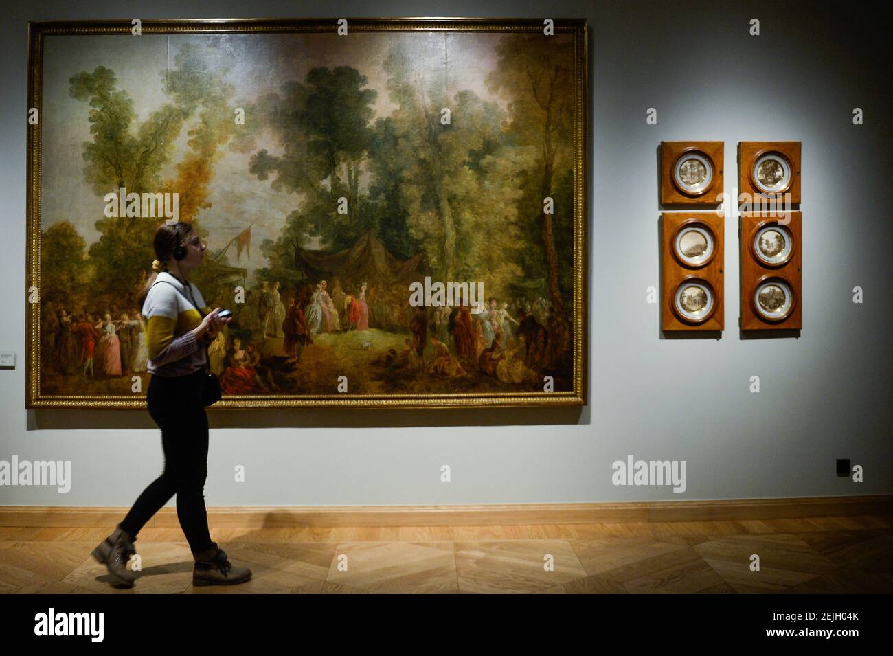 A visitor walks by a painting at a recently opened Palace of the ...