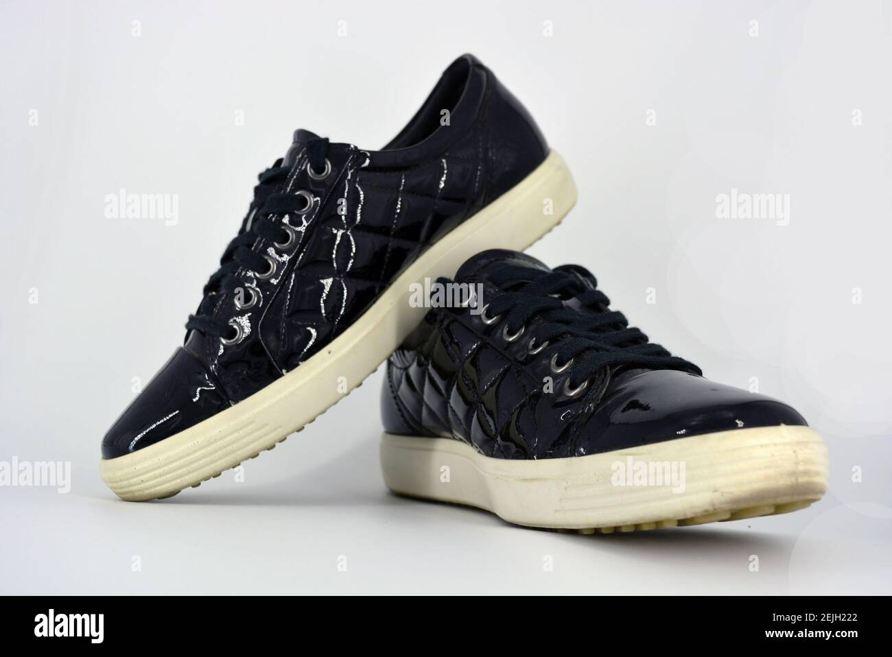 Stylish bright black lacquer shoes located on a white background ...