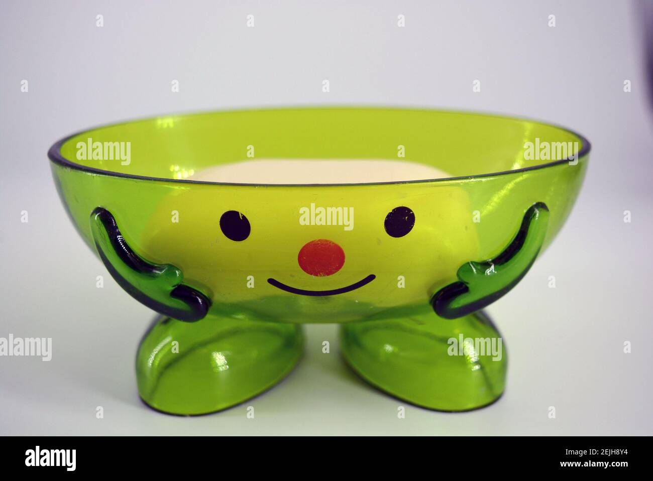 White soap lies in a transparent green plastic soap with smile Stock ...