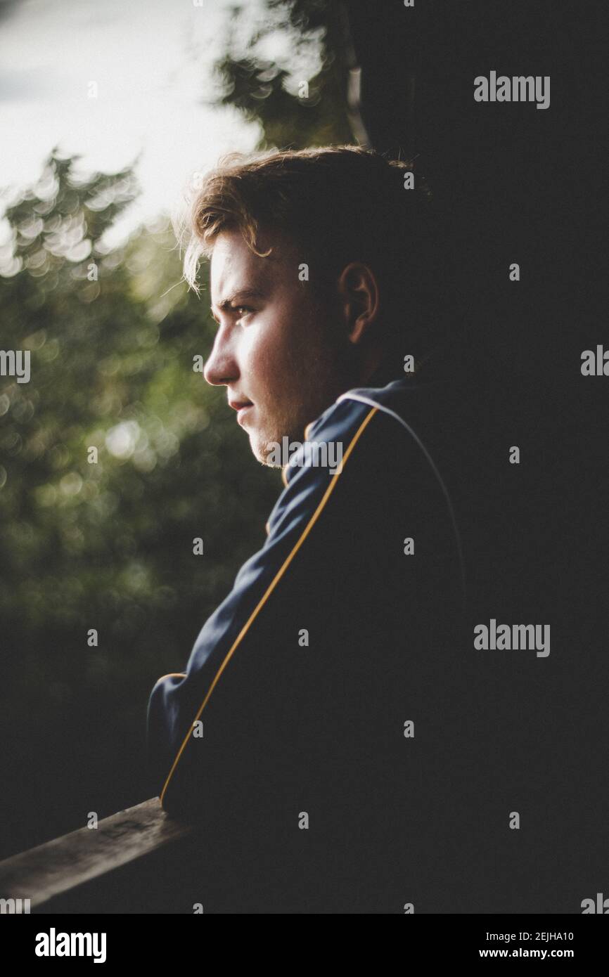 Side view of a young guy looking out of the window Stock Photo - Alamy