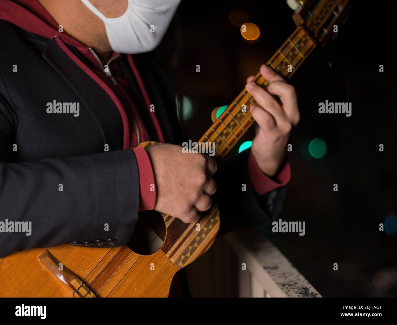 Man in a mask playing guitar on the balcony of his house - the concept ...