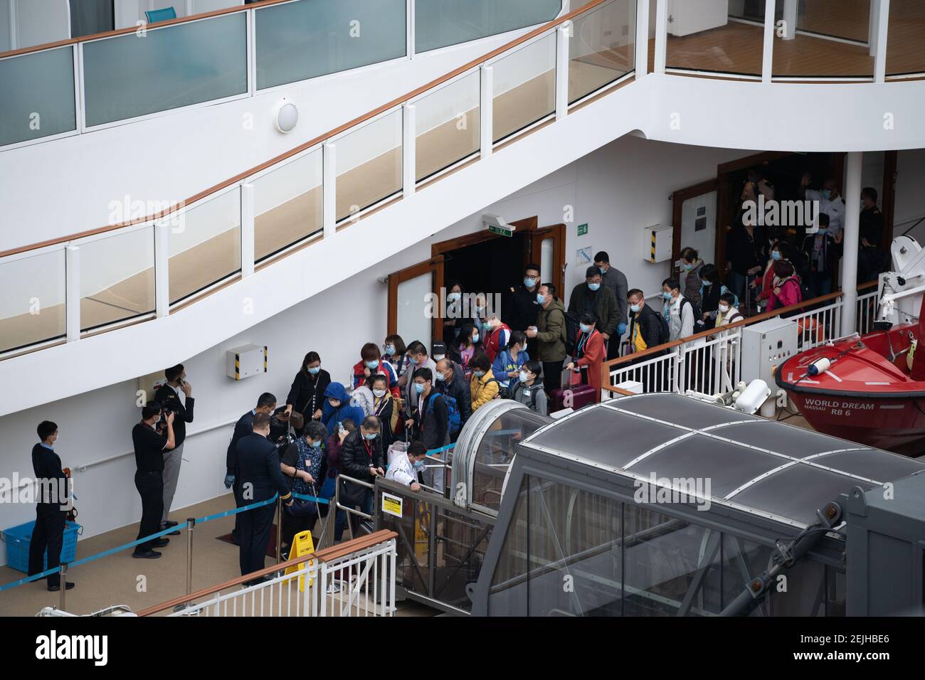 Passengers queue up to finally disembark from the World Dream cruise ...