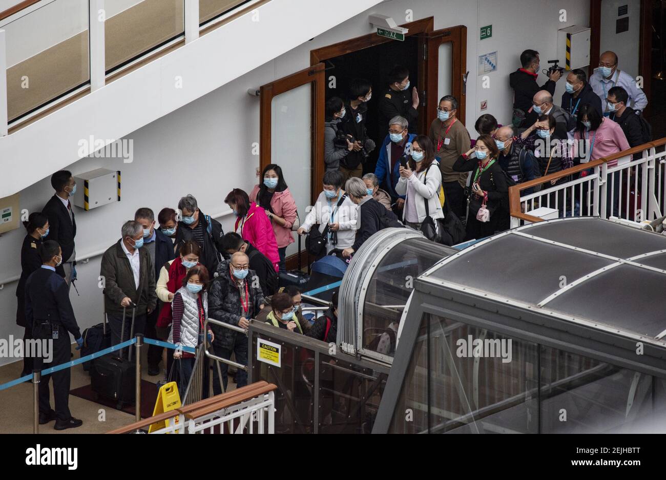 Passengers queue up to finally disembark from the World Dream cruise ...