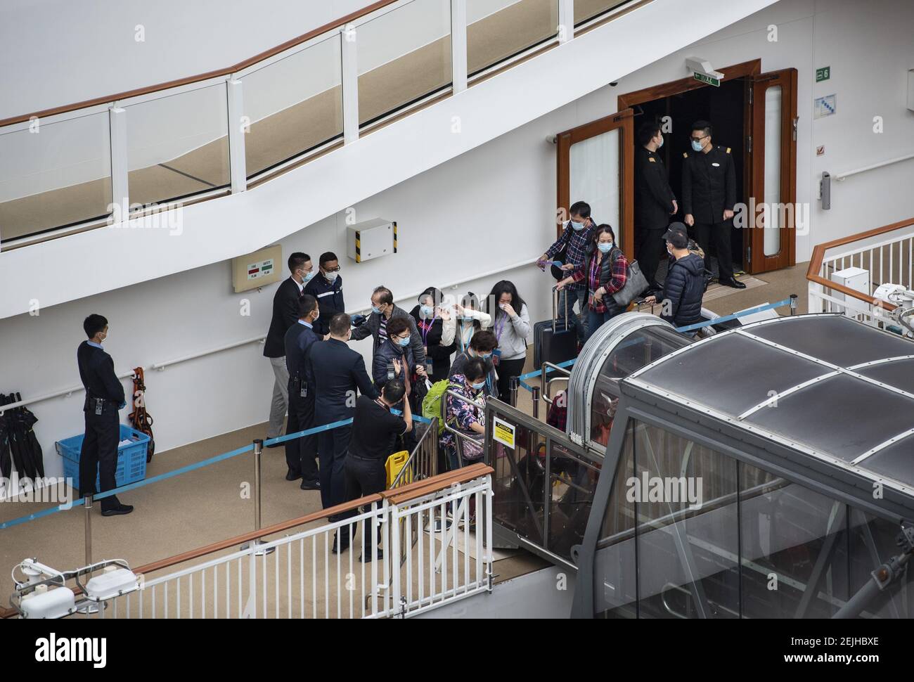Passengers queue up to finally disembark from the World Dream cruise ...