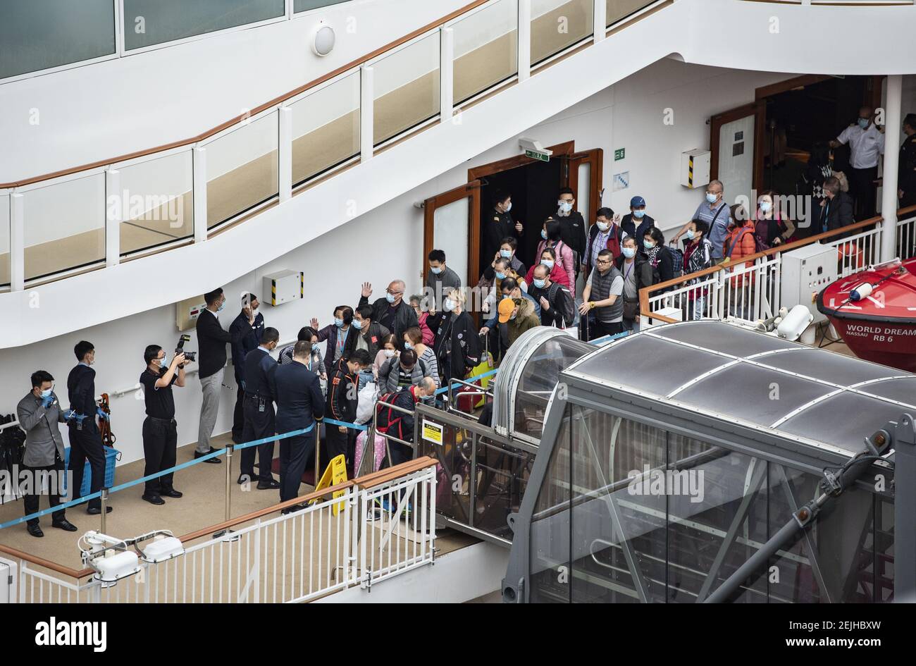 Passengers queue up to finally disembark from the World Dream cruise ...