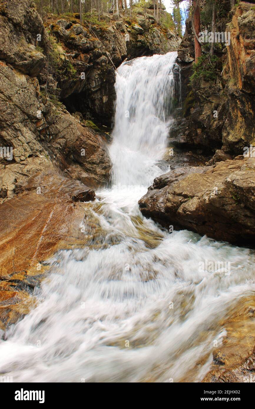 A tall waterfall flows through a canyon Stock Photo - Alamy