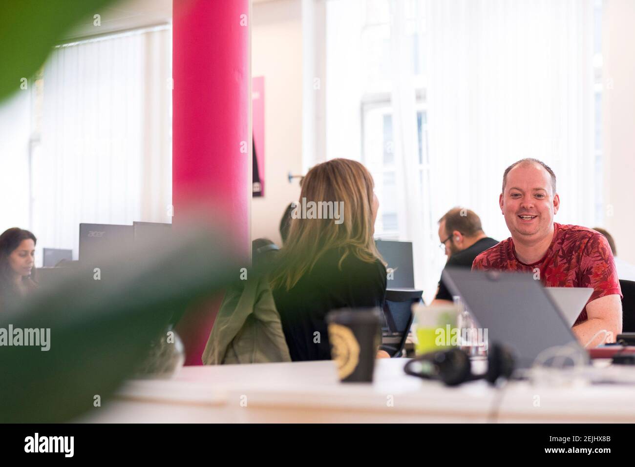 People sat at the work desk in an office and working Stock Photo - Alamy