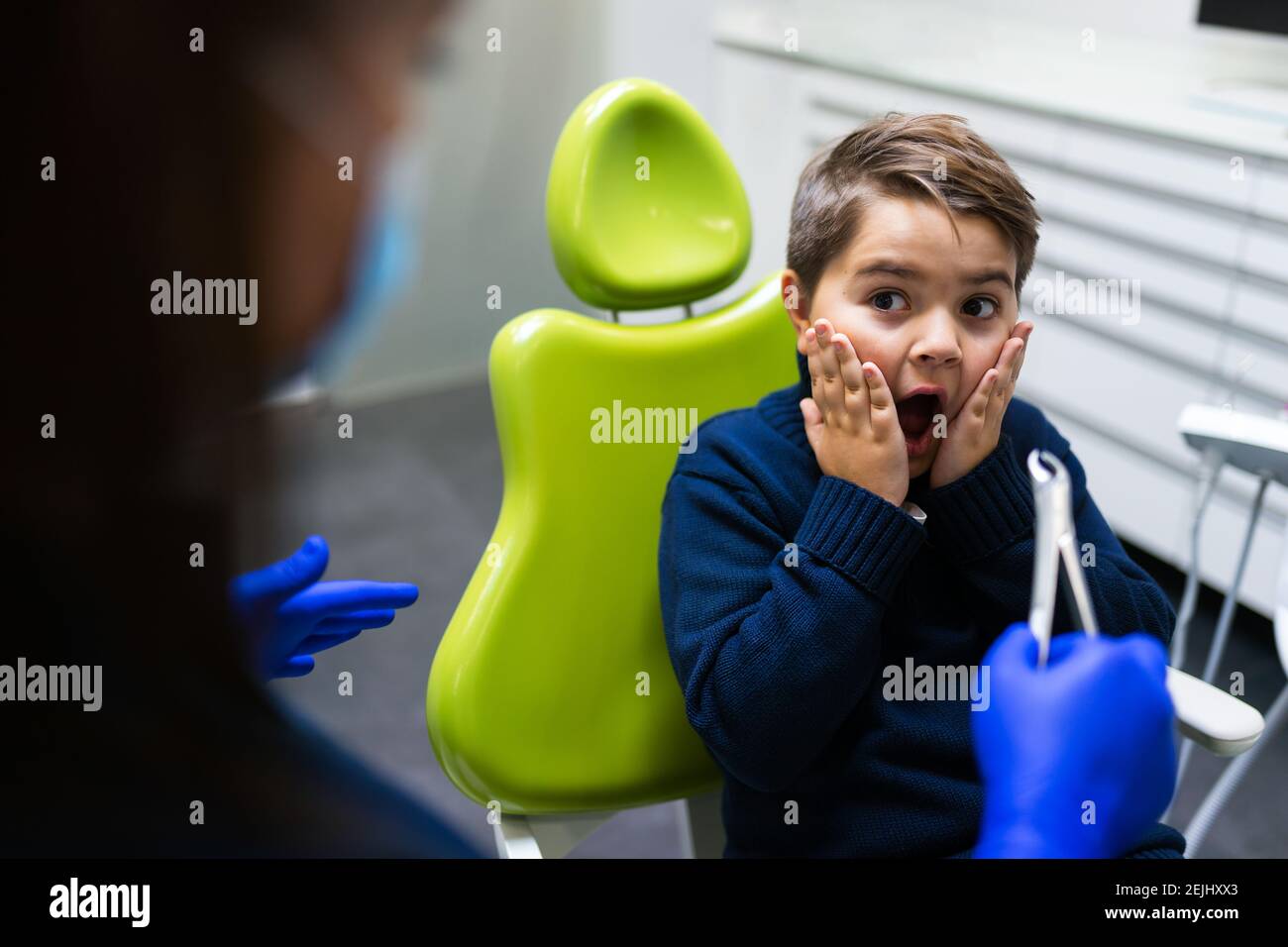Boy scared of dentist with forceps. Сhild is afraid to remove tooth ...