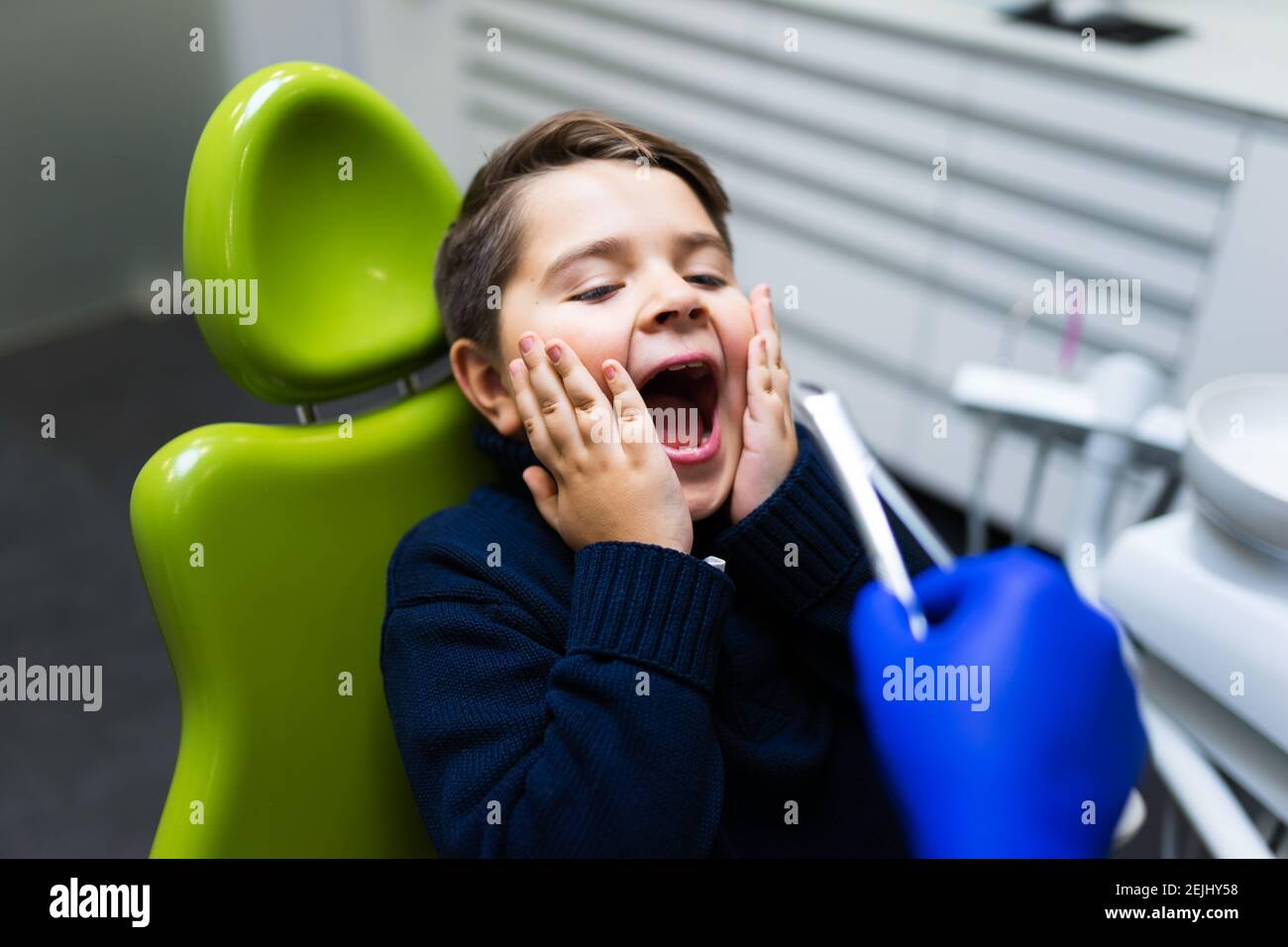 Boy scared of dentist with forceps. Сhild is afraid to remove tooth ...
