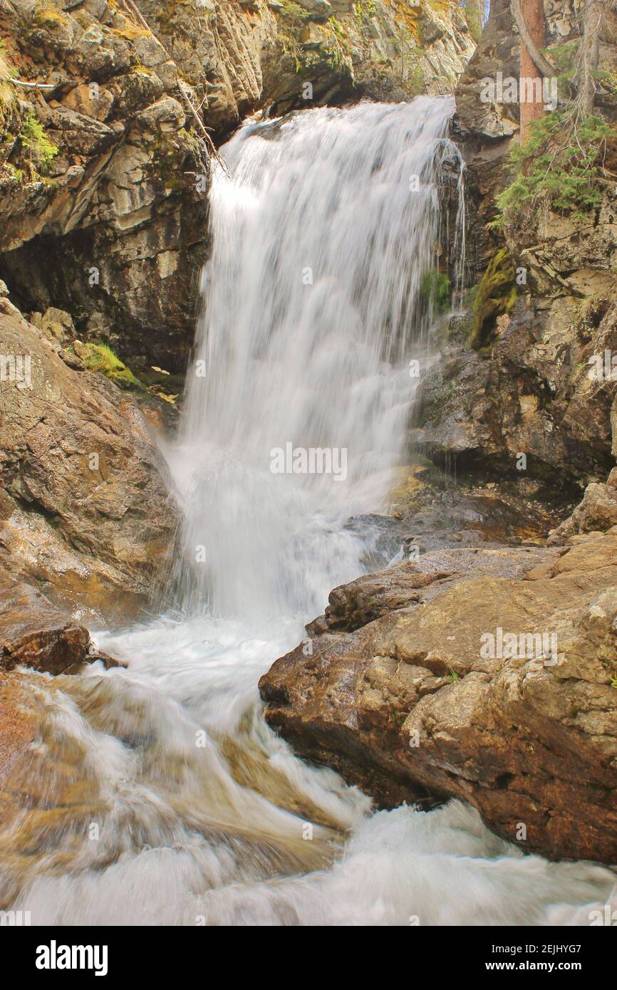 A tall waterfall flows through a canyon Stock Photo - Alamy