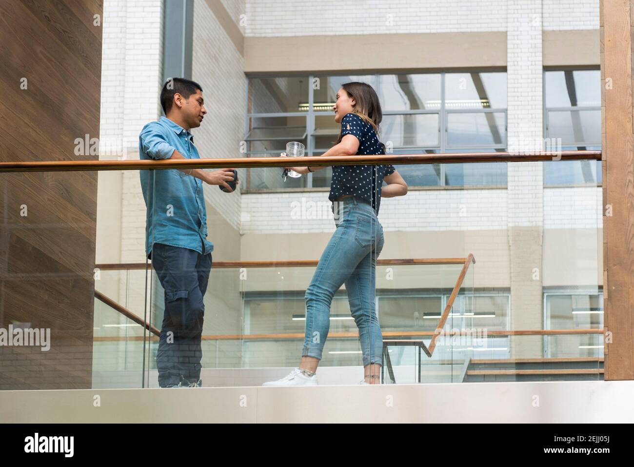 Two work colleagues chatting, listening and catching up in the communal ...